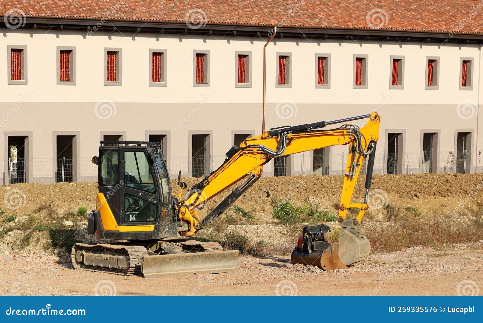 Compact Excavator At Work Among The Foundations And The Pillars Of A ...
