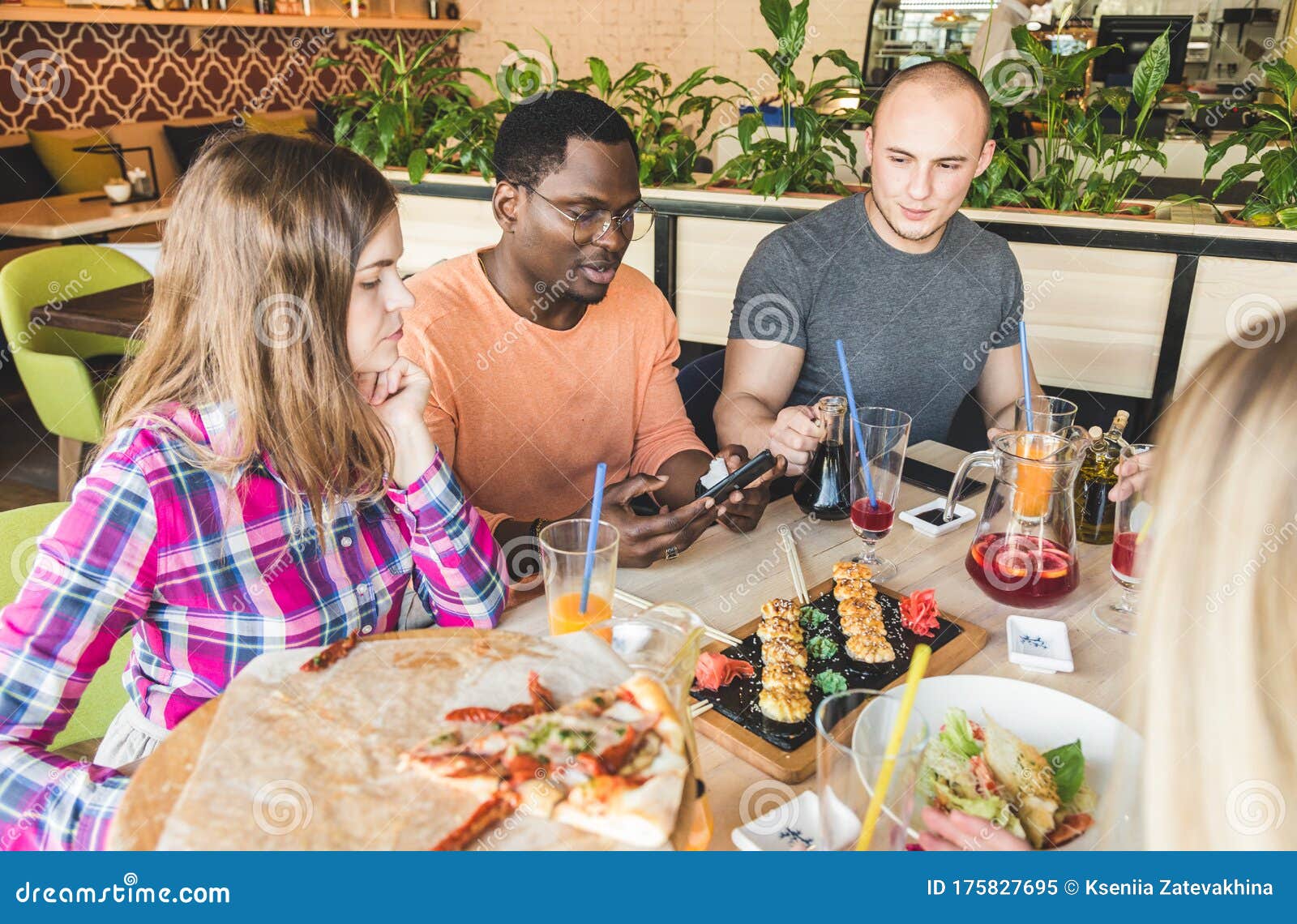 A Company of Multicultural Company Young People in a Cafe Eating Sushi ...