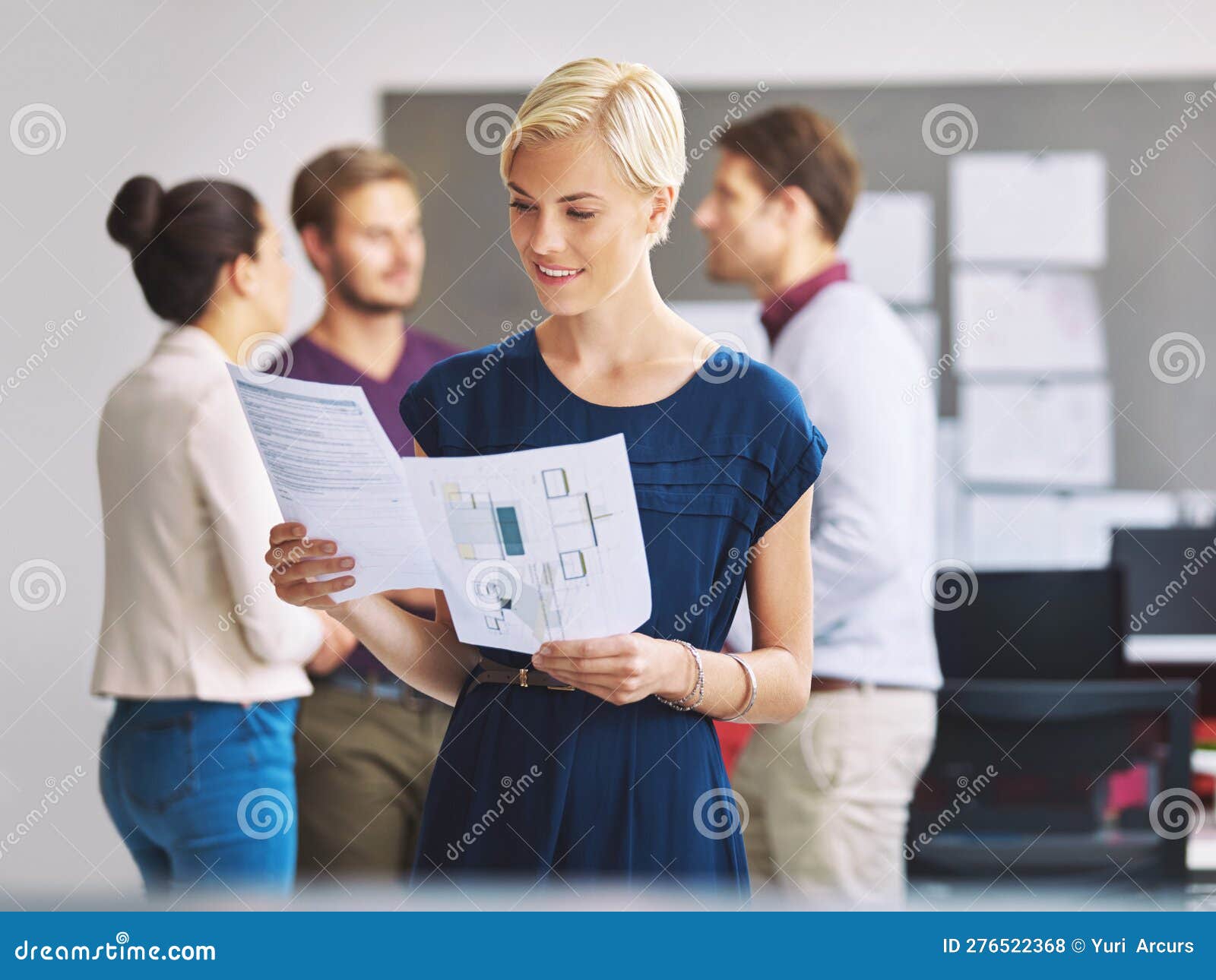 Comparing Notes. a Young Female Designer Looking Over Some Paperwork ...