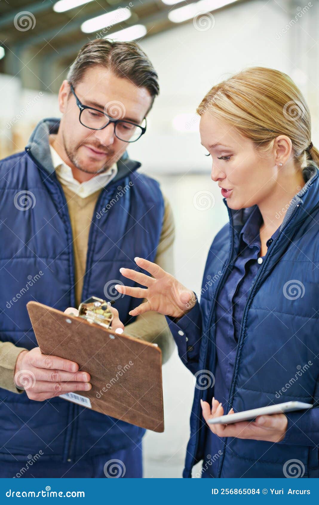 Comparing Their Paperwork. Two People Looking at Paperwork while ...
