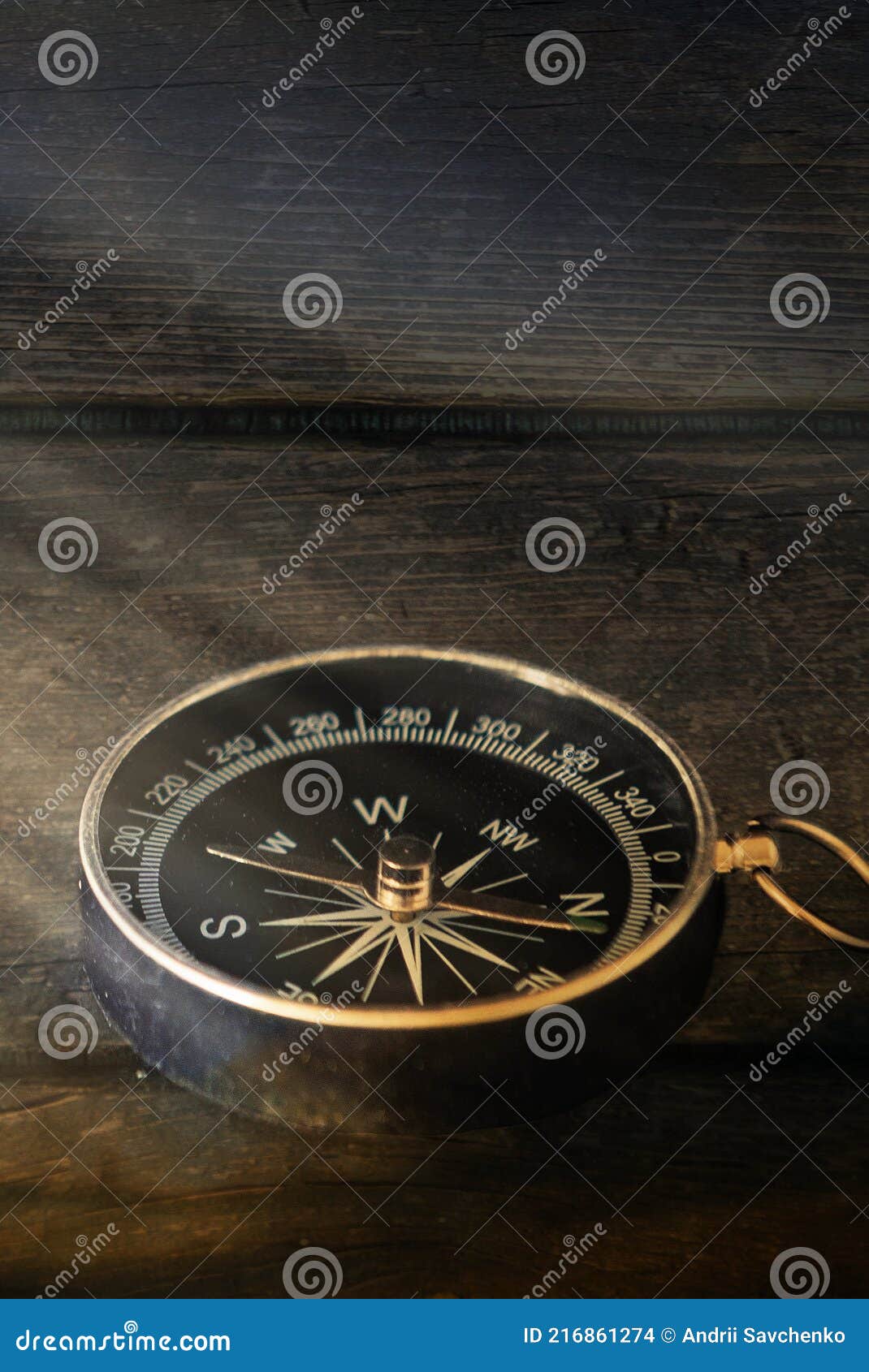 Compass on a Dark Wooden Background with Rays of Light. Vertical Image ...