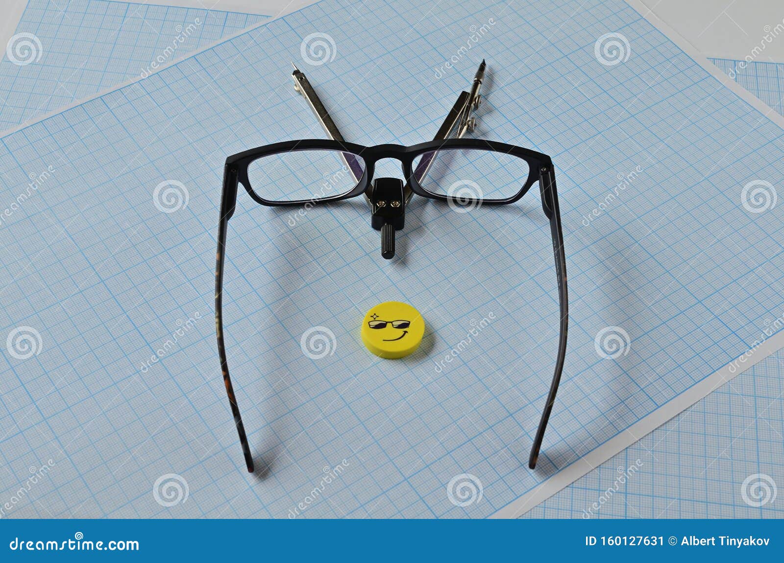 A Compass, Goggles and a Yellow Eraser on Graph Paper for Drawing ...
