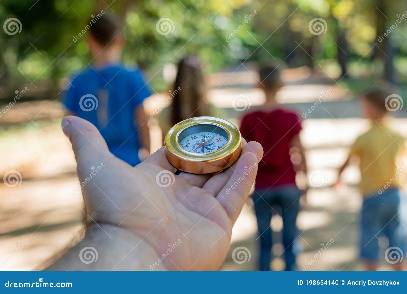 Compass in Hand Against the Background of Standing Children in the ...