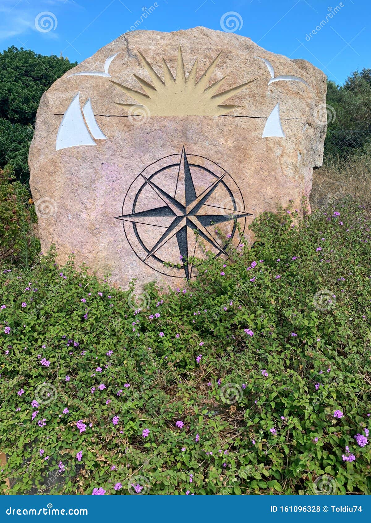 Compass Rose Painted on a Rock Surrounded by Green Bushes Editorial ...