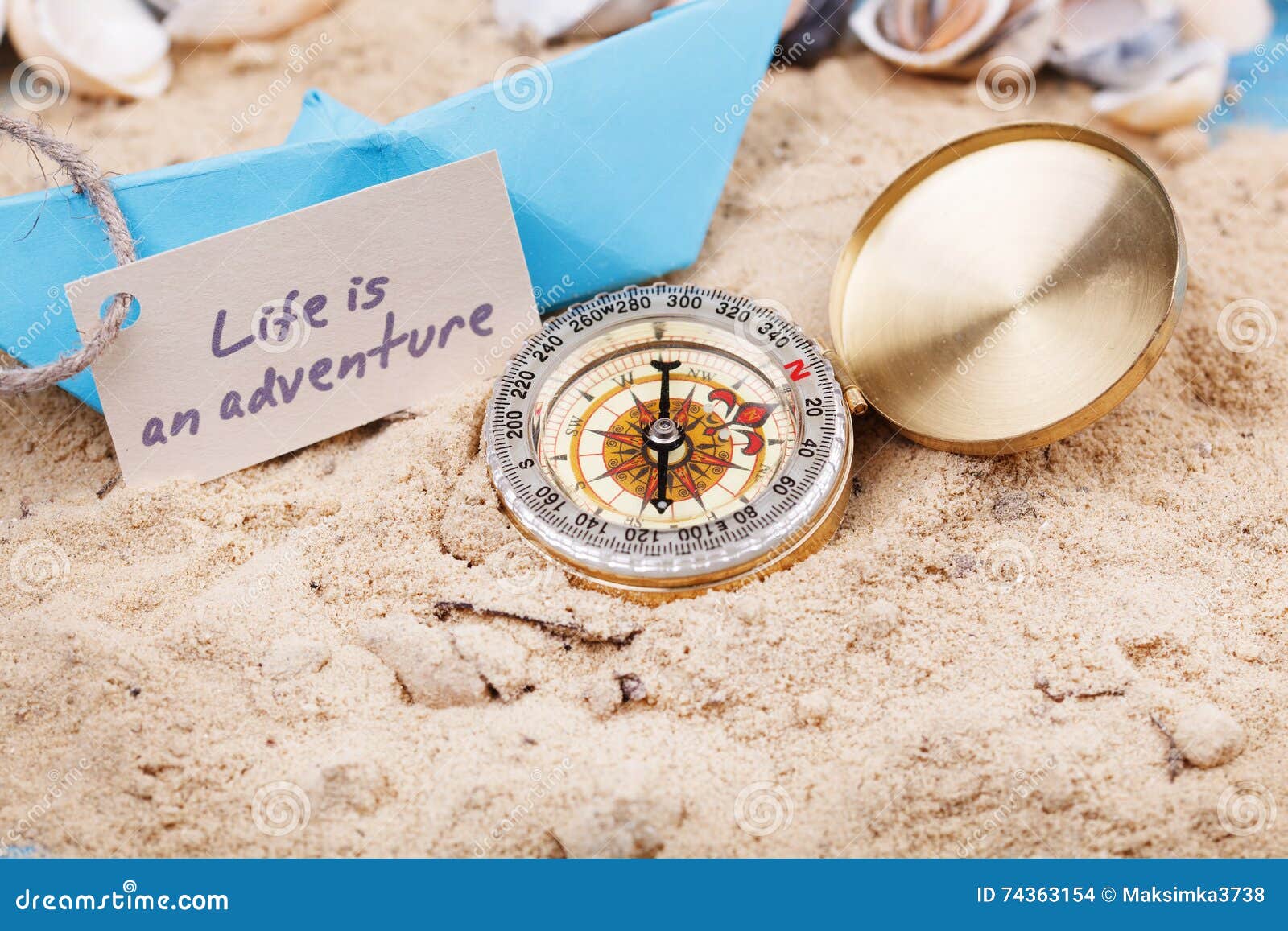 Compass in the Sand with Sign - Life is an Adventure Stock Photo ...