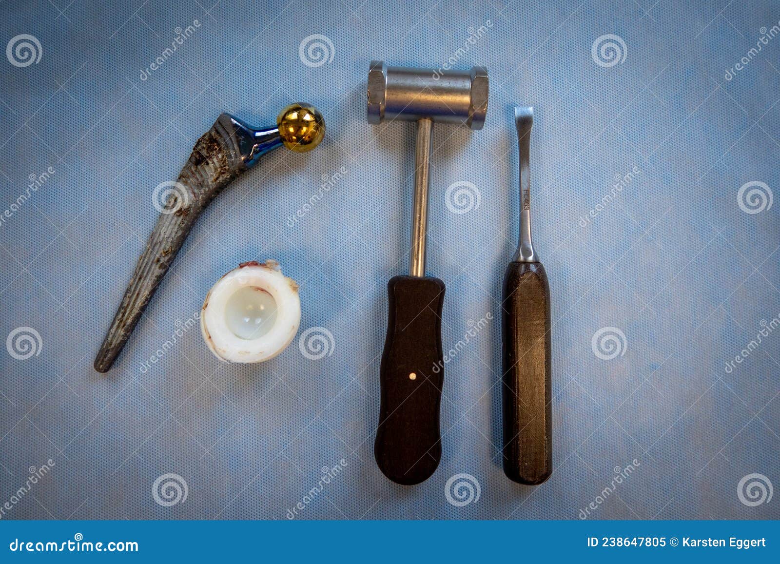 A Complete Explanted Hip Prosthesis Lies Next To a Hammer and a Chisel ...