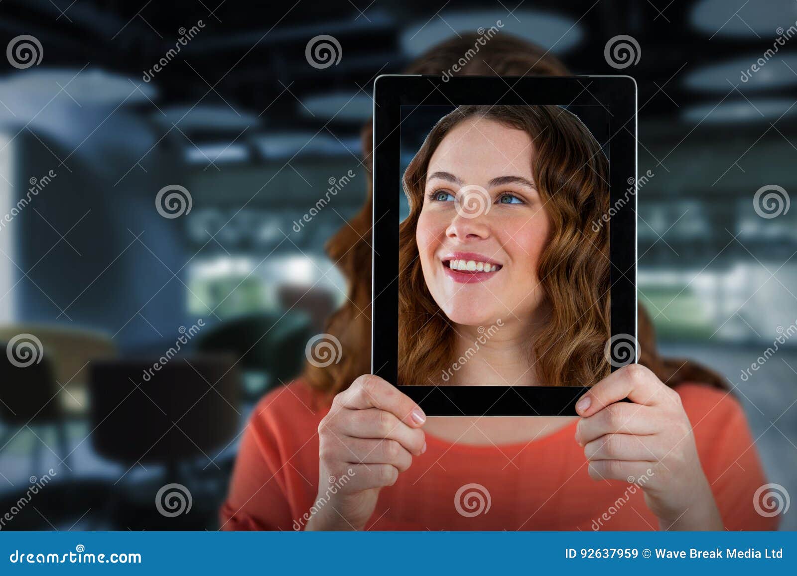 Composite Image of Woman Holding Digital Tablet in Front of Her Face ...
