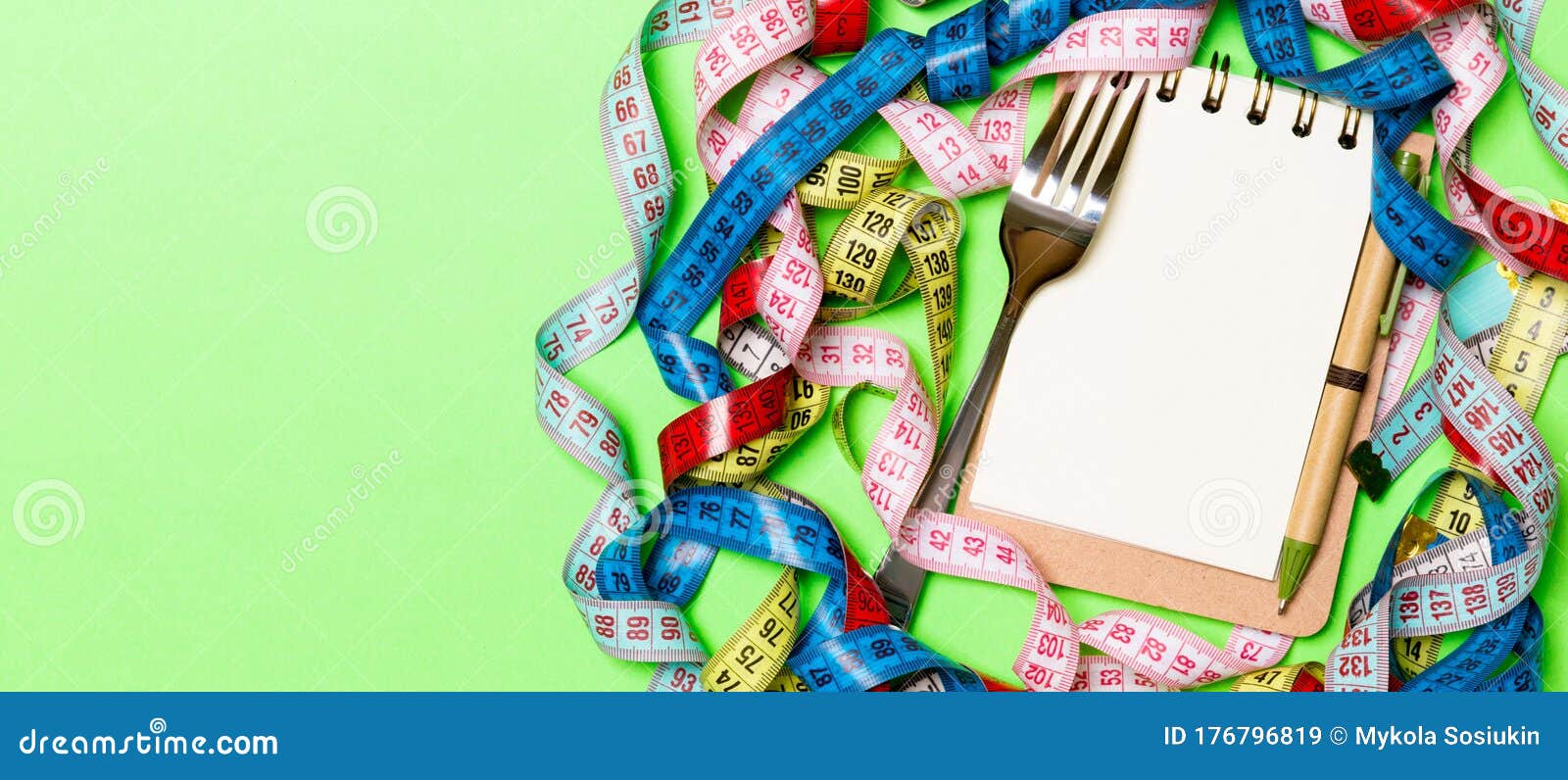 Composition of Colorful Measuring Tapes, Fork, Pen and Notepad on Green ...