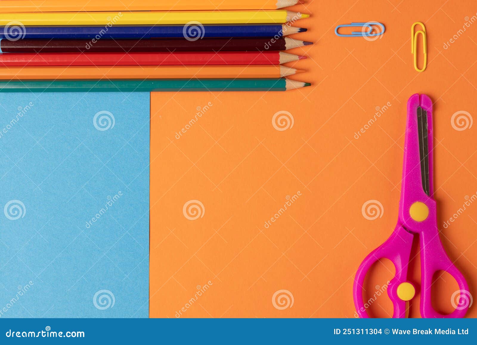 Composition of Crayons, Scissors and Clips on Blue and Orange Surface ...