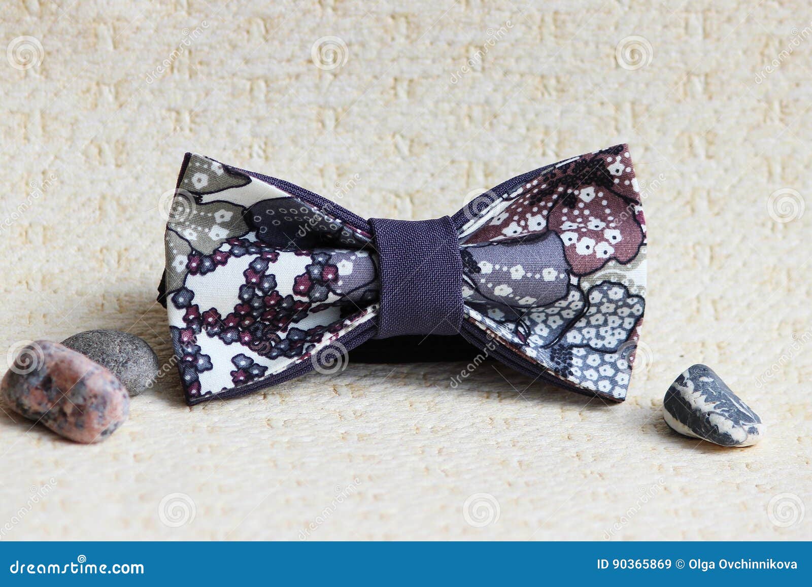 Composition: Extravagant Bow Tie and Small Stones on a Beige Background ...