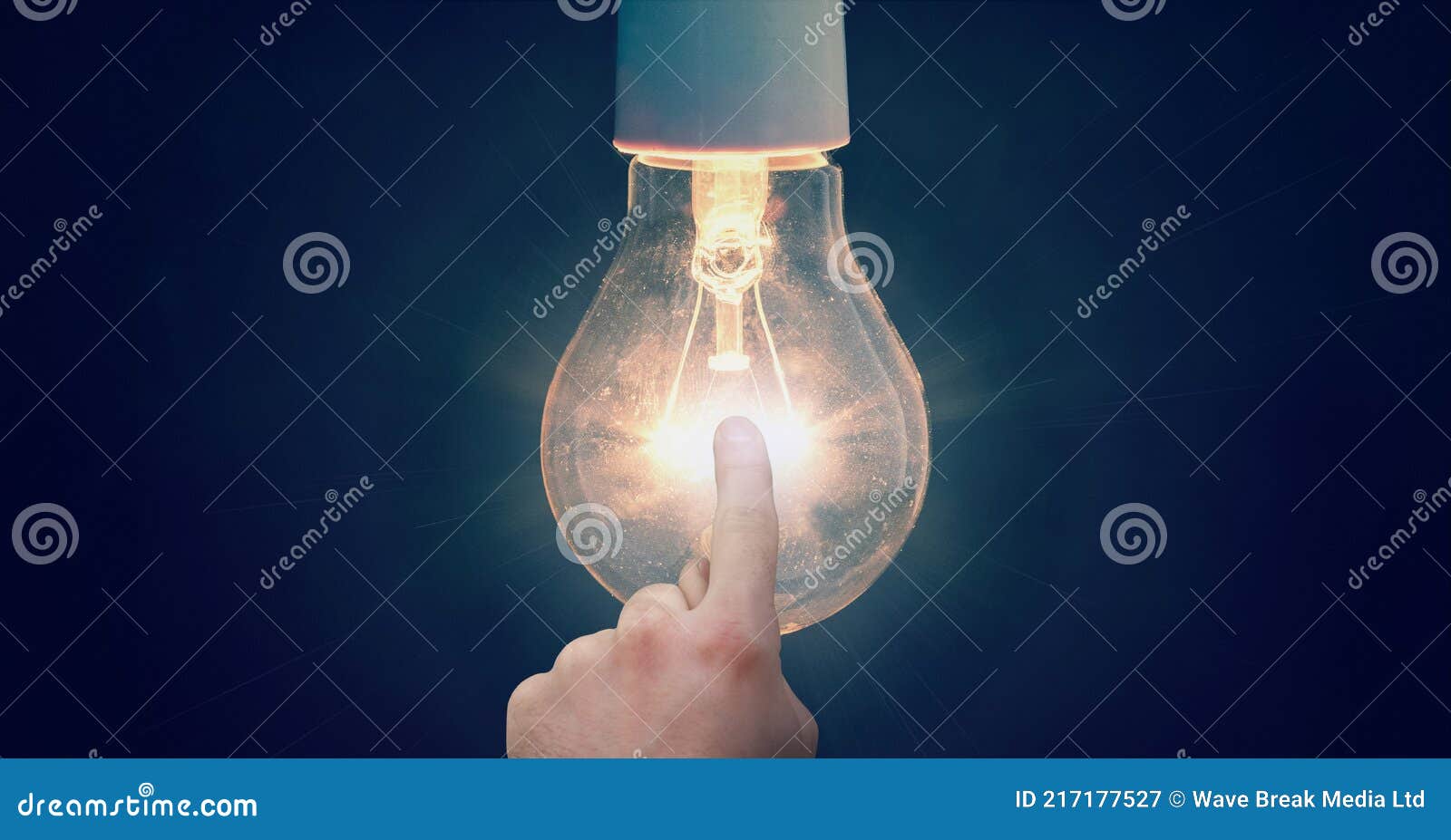Composition of Finger Touching Lit Light Bulb on Blue Background Stock ...