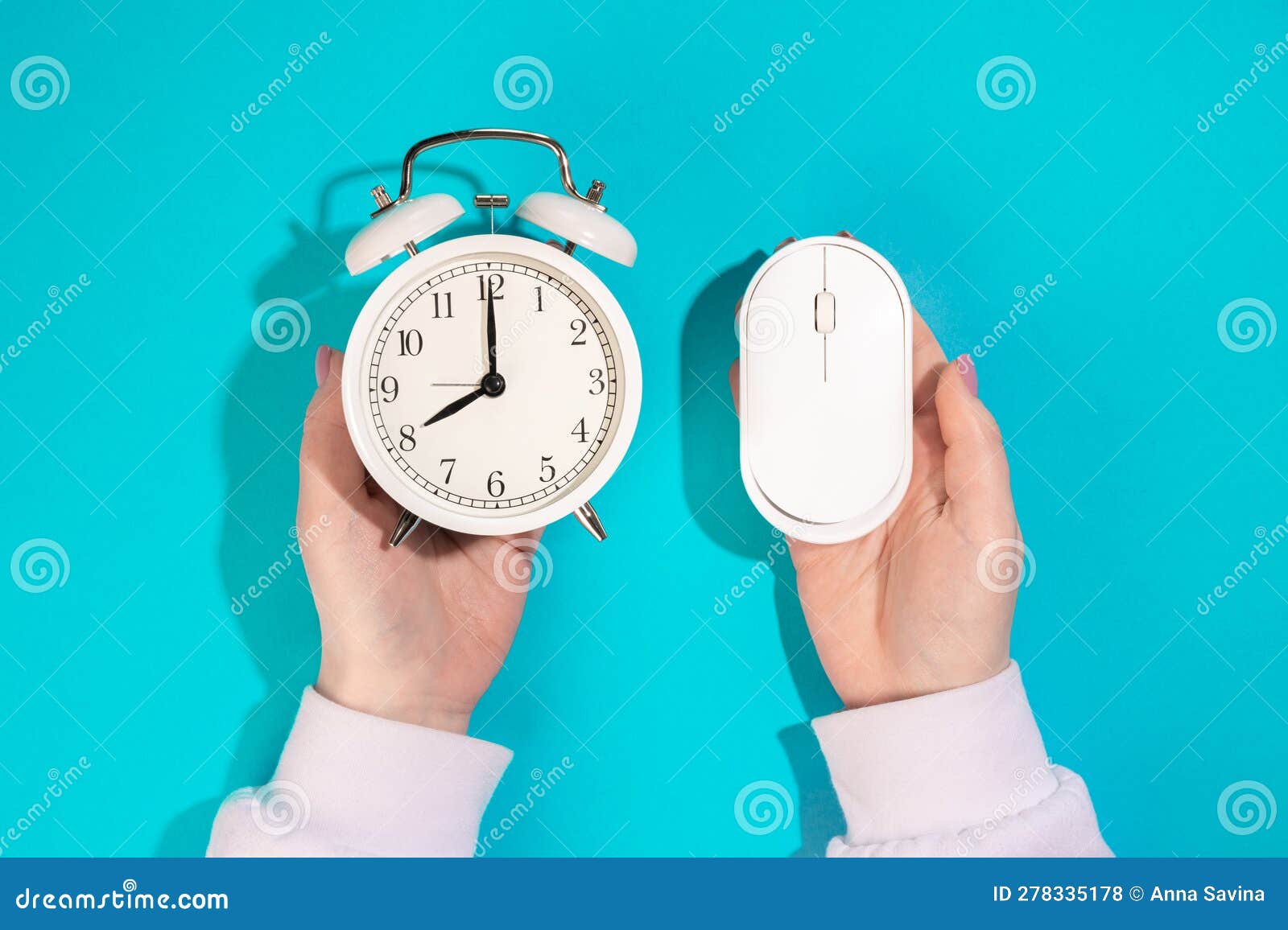 Computer Mouse and Alarm Clock in Female Hands on a Blue Background ...
