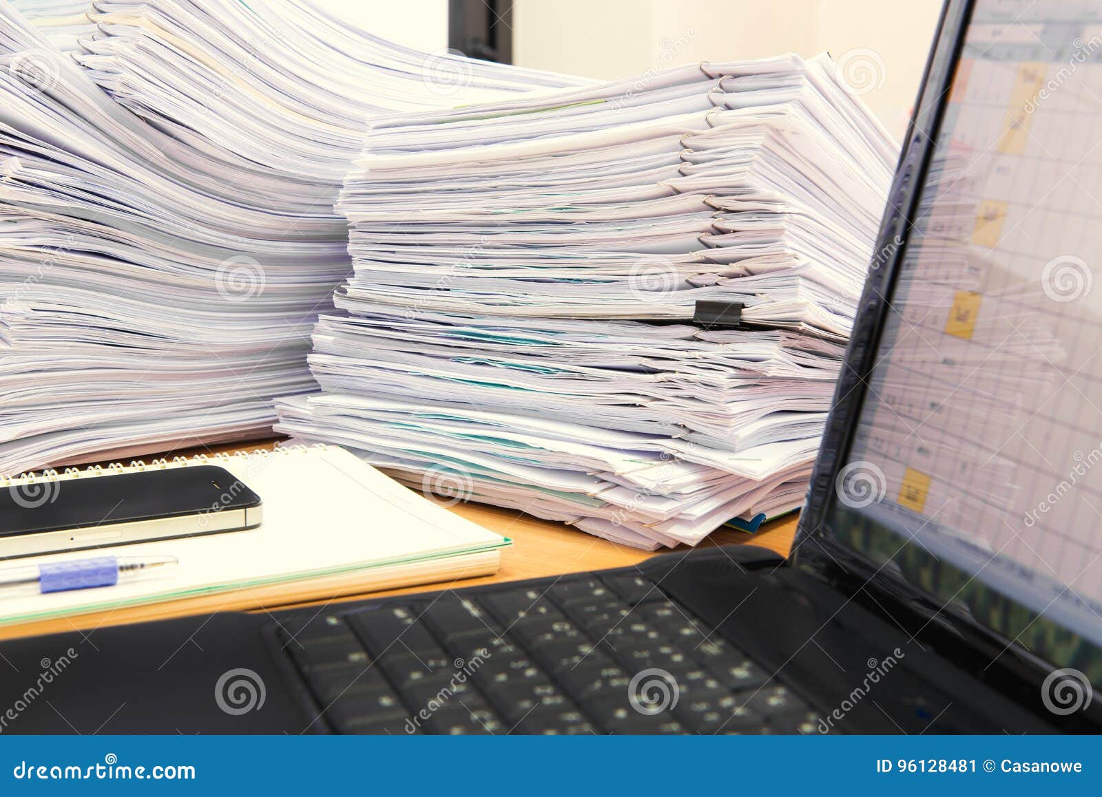 Computer Notebook and Documents on Desk Stack Up High Waiting To Stock ...