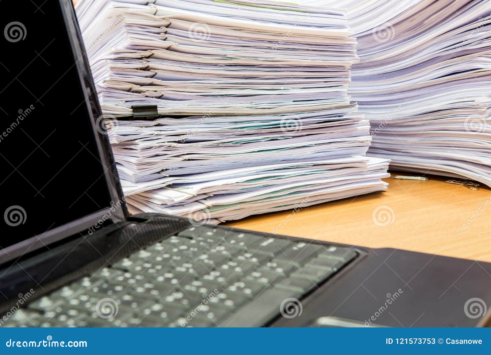 Computer Notebook and Documents on Desk Stack Up High Waiting To Stock ...