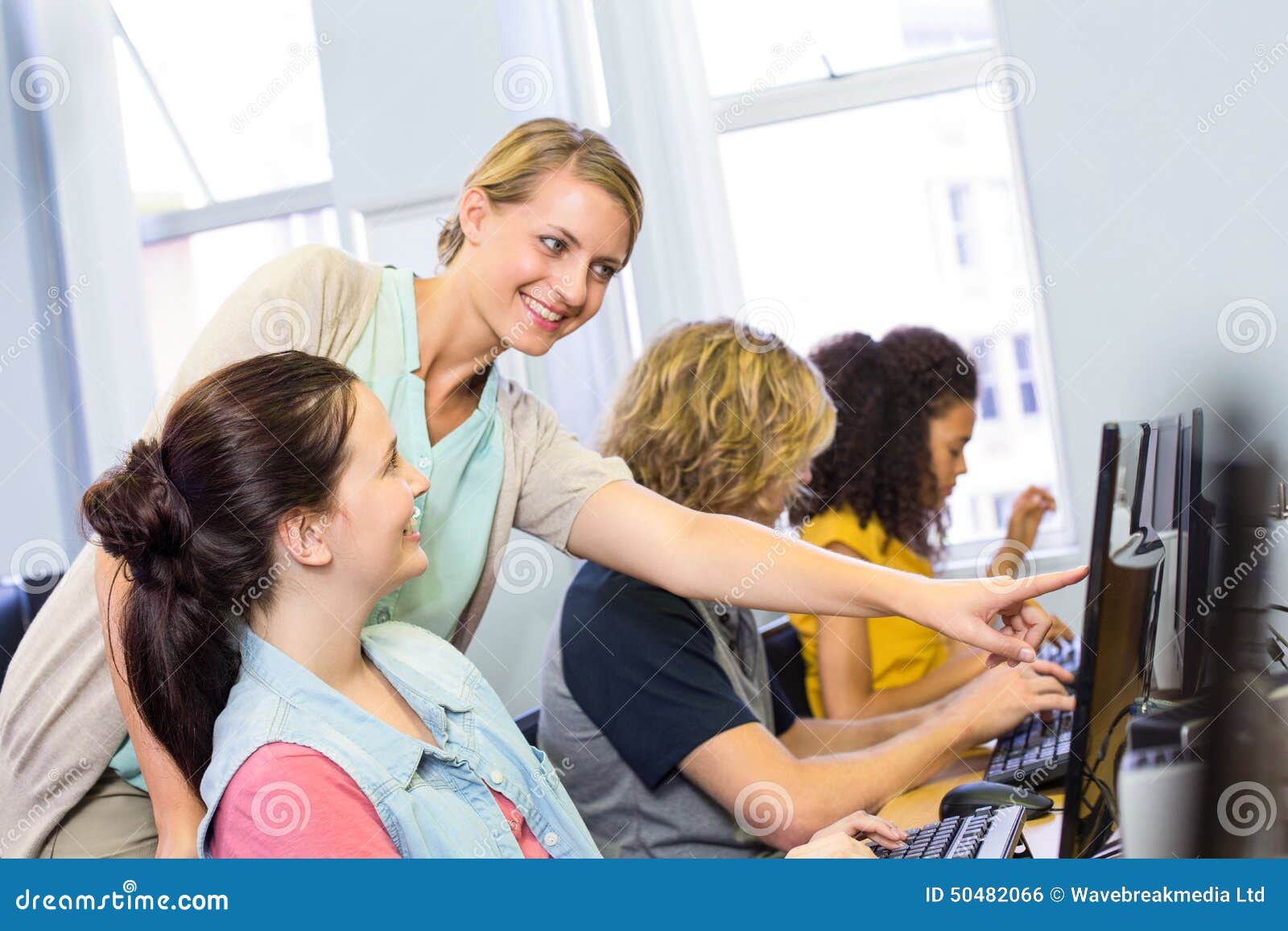 Computer Teacher Helping Female Students Stock Photo - Image of ...