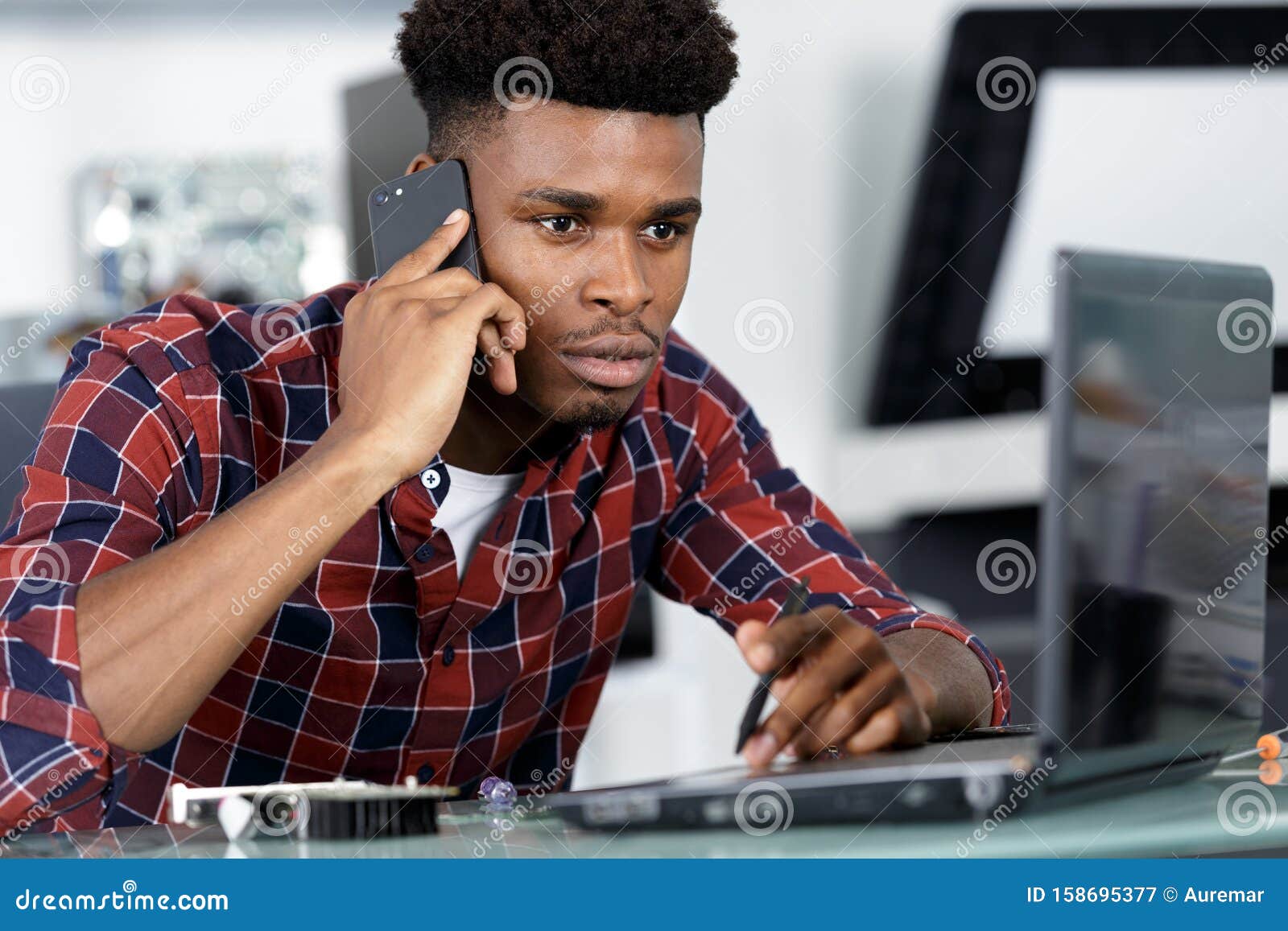 Computer Technician Using Laptop and Speaking on Smartphone Stock Image ...
