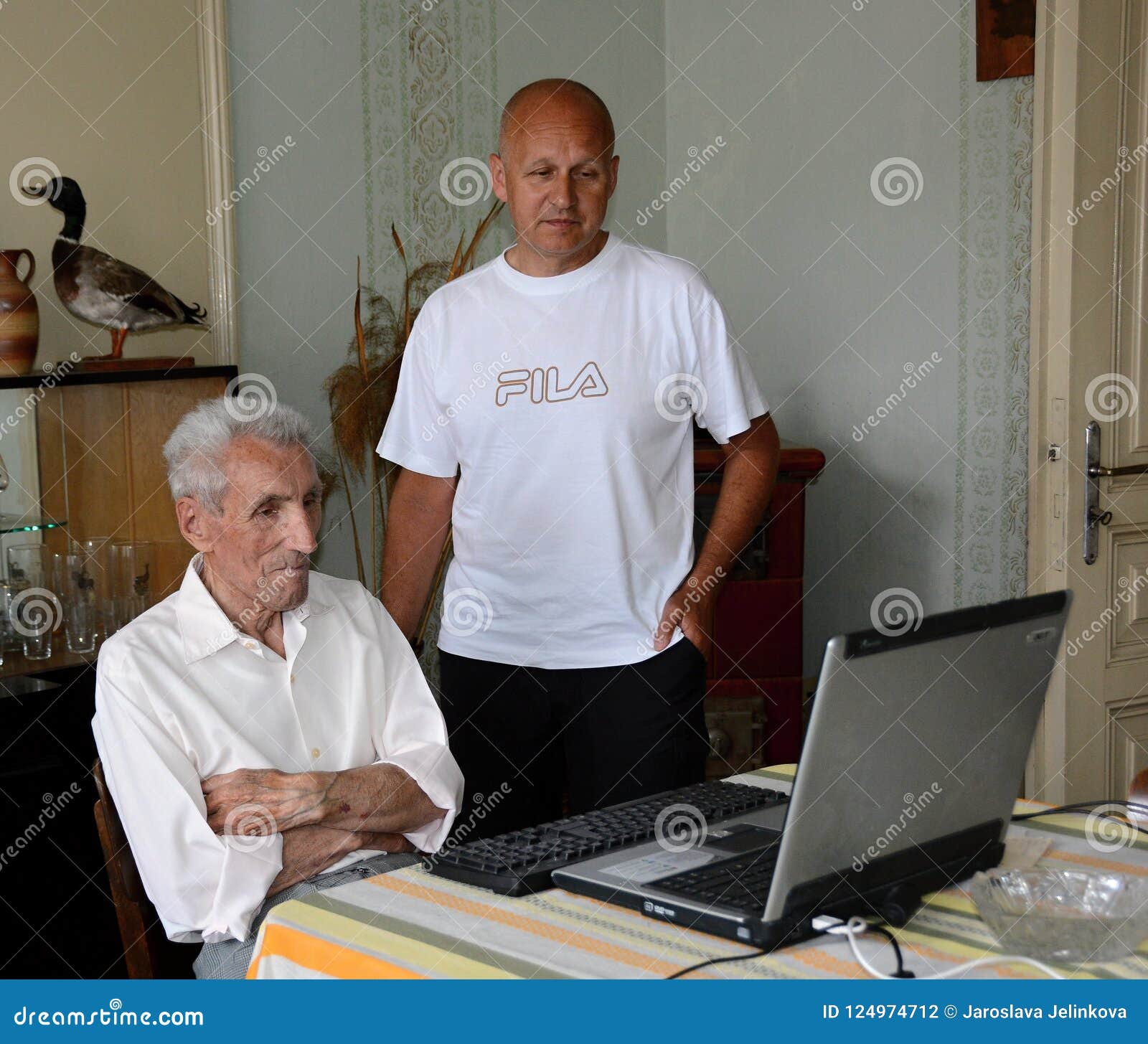 An Older Man 88 Years Works on a Laptop and a Younger Man 60 Years Old ...