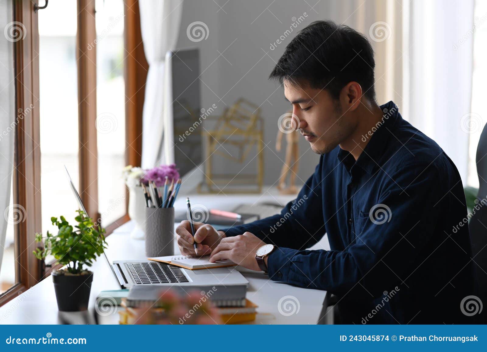 Concentrated Man Working with Laptop Computer and Making Notes on ...