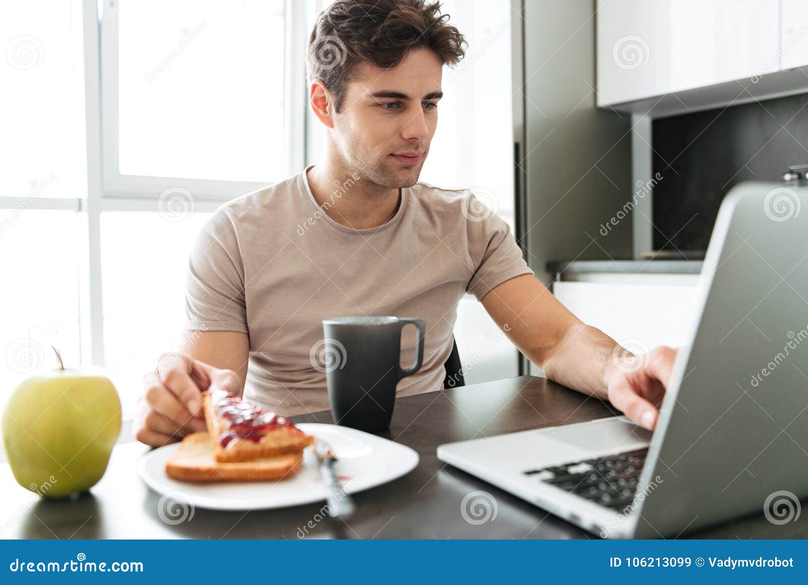 Concentrated Attractive Man Using Laptop while Eating Breakfast Stock ...