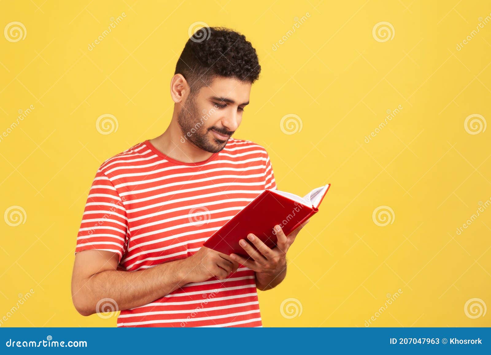 Concentrated Bearded Man Holding Book And Smiling Enjoying Reading
