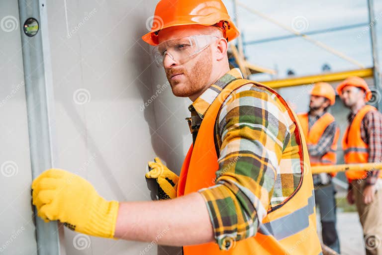 Concentrated Builder Using Bubble Level at Construction Site while His ...