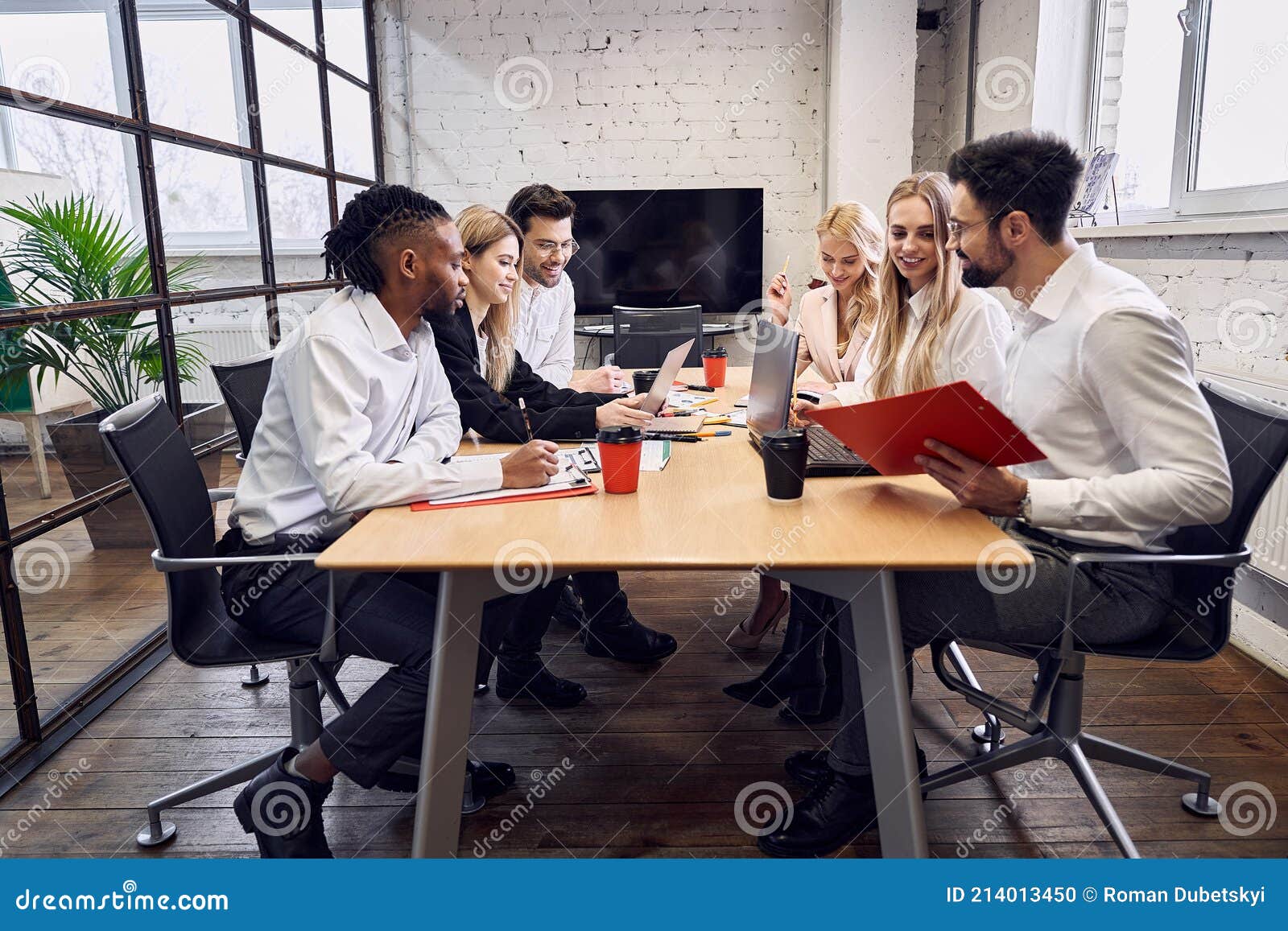 Concentrated Business People Communicating with Each Other while ... Concentrated Business People Communicating with Each Other while ...