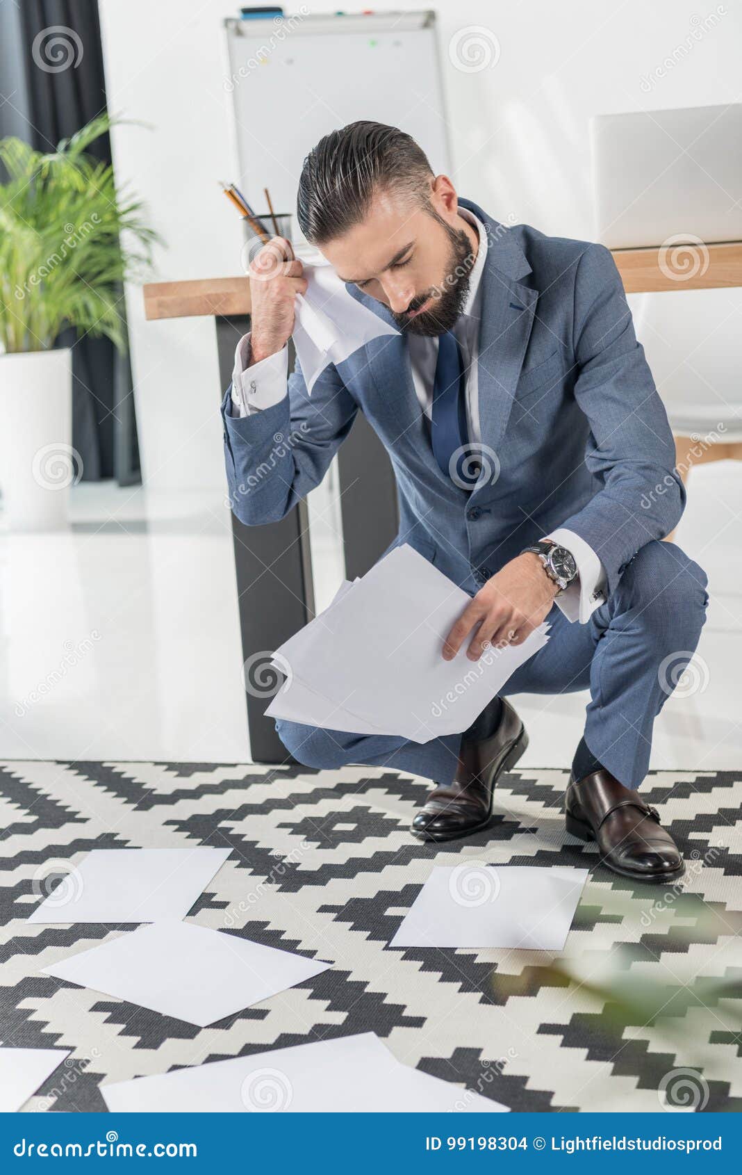 Businessman Looking at Papers on Floor at Modern Office Stock Photo ...