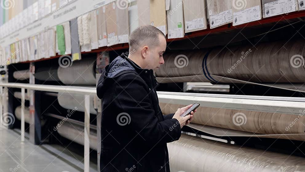 Focused Customer Browsing Smartphone, Comparing Linoleum Samples while ...