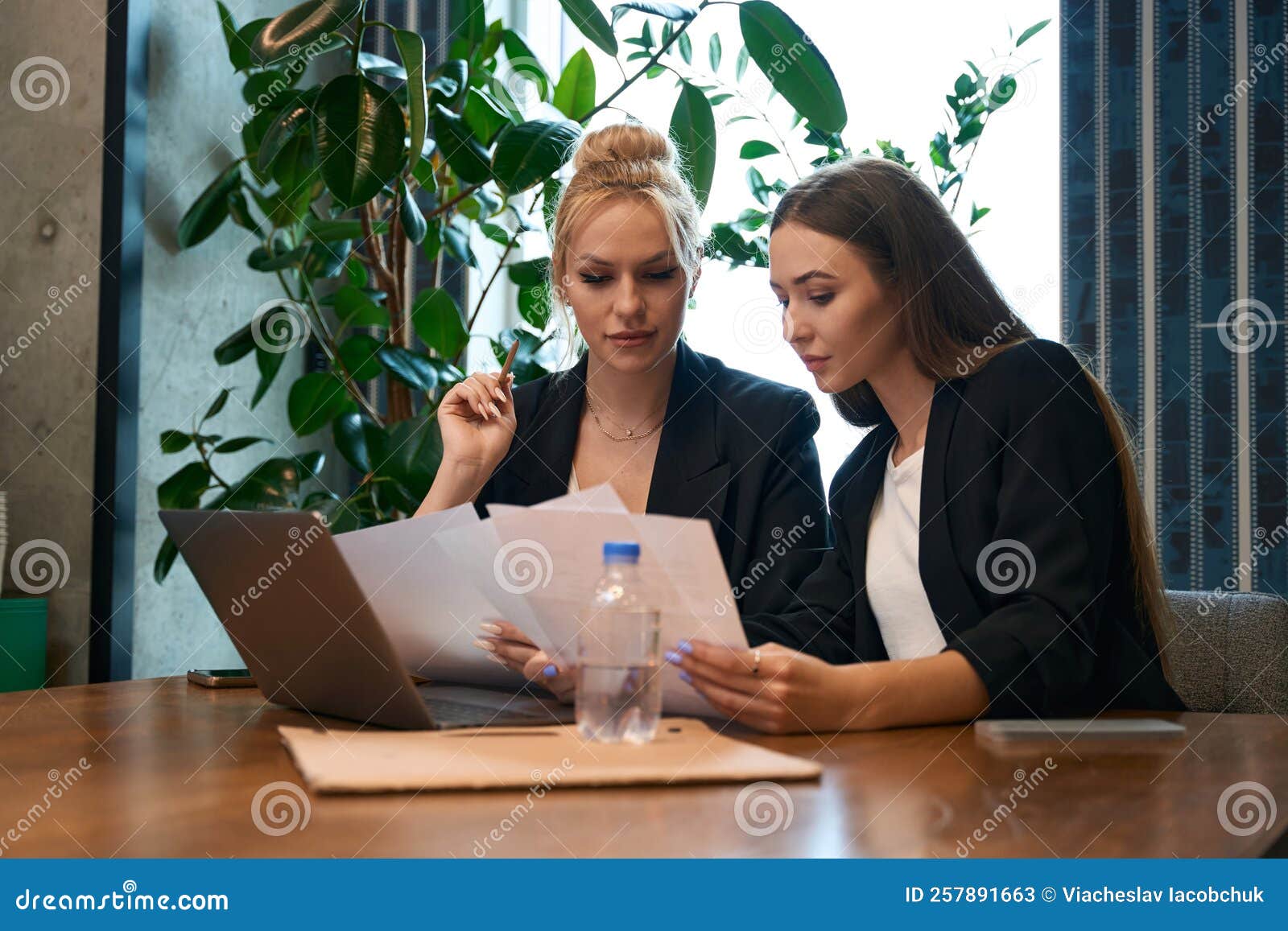 Concentrated Female Colleagues Dealing with Business Documentation ... Concentrated Female Colleagues Dealing with Business Documentation ...