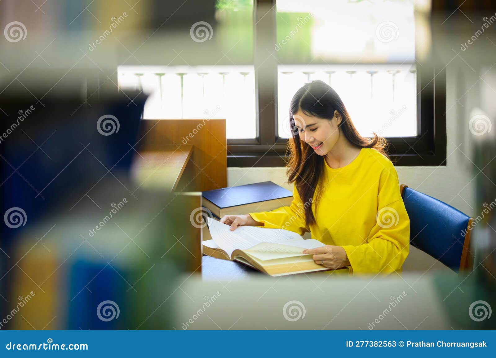 Concentrated Female Student Reading Book, Doing Class Assignment in ...