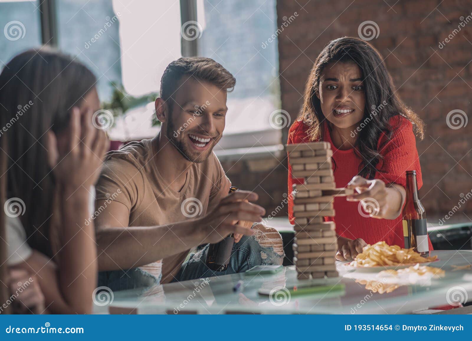 Concentrated Friends Playing Jenga at the Party Stock Photo - Image of ...