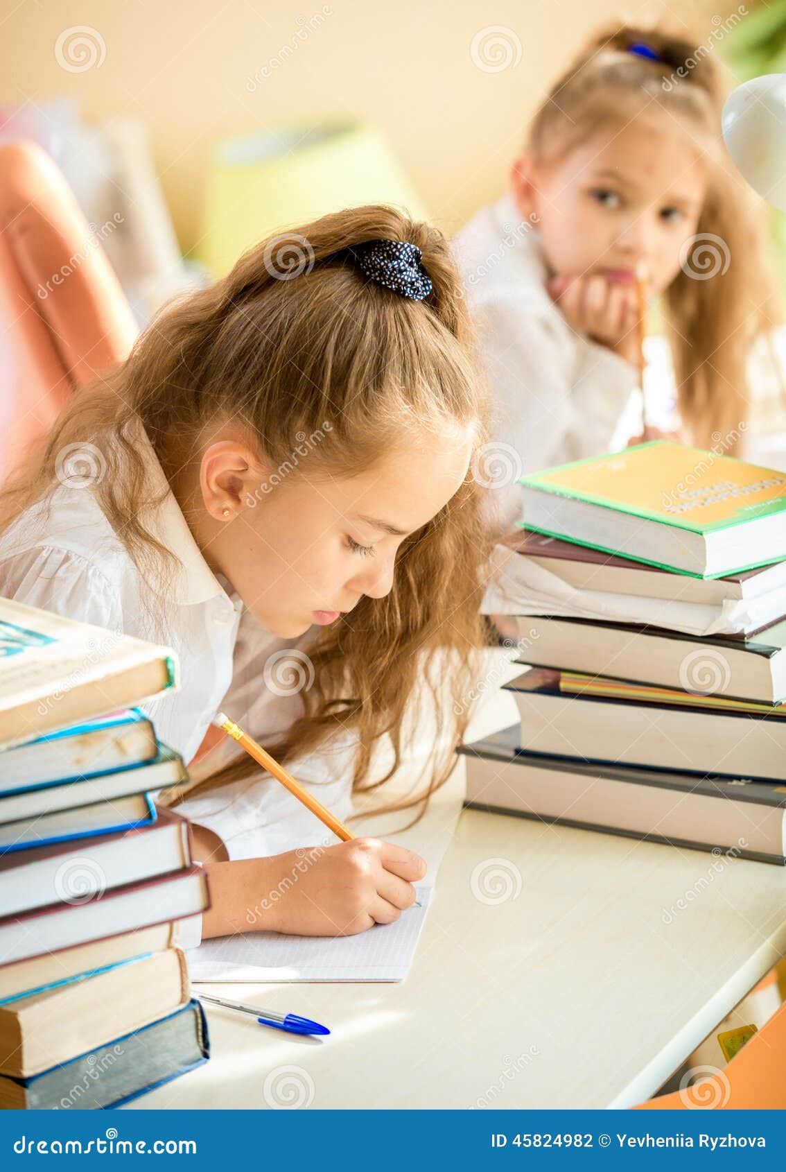 Concentrated Girl Doing Homework while Classmate Trying To Write Stock ...