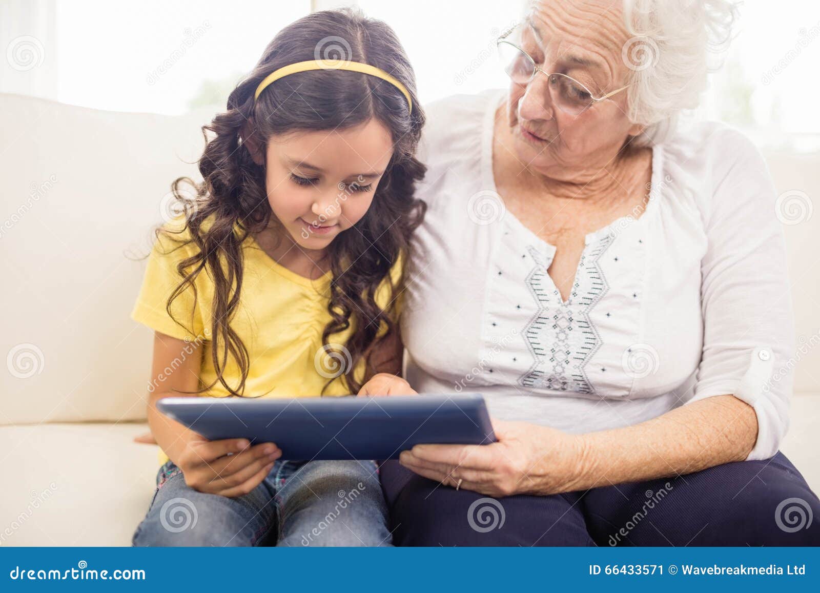 Concentrated Granddaughter Using Tablet with Grandmother Stock Image ...