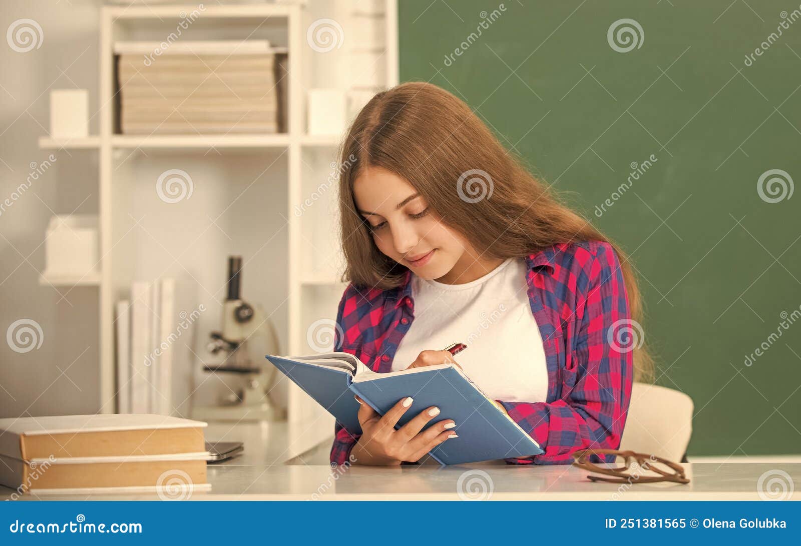 Concentrated Kid Making Notes in Copybook in Classroom at Blackboard ...