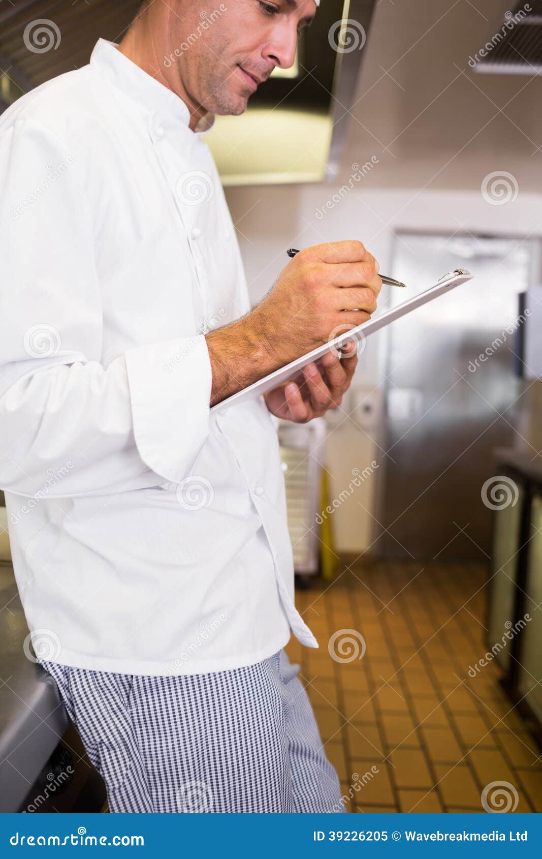 Concentrated Male Cook Writing on Clipboard in Kitchen Stock Image ...
