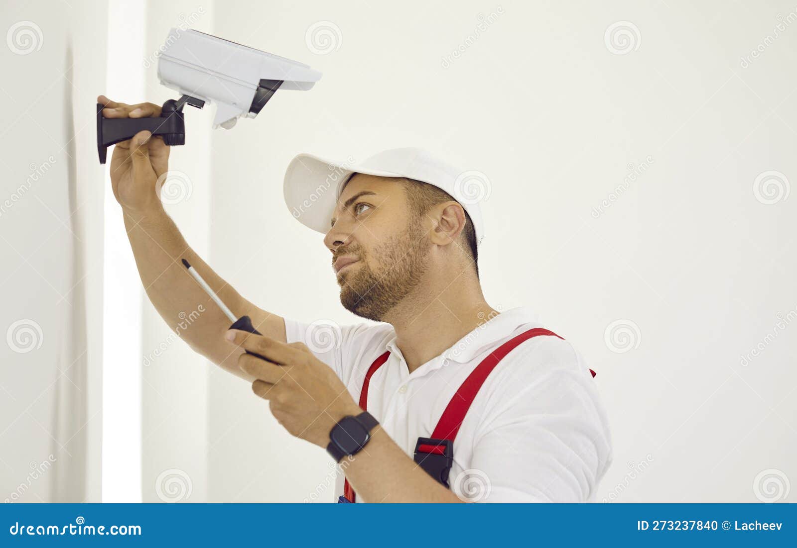 Concentrated Male Installer is Using Screwdriver To Mount CCTV Camera ...