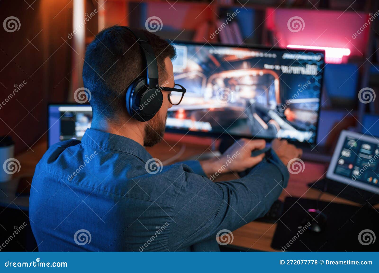 Concentrated Man is Playing the Shooter Game on His Computer. Neon ...