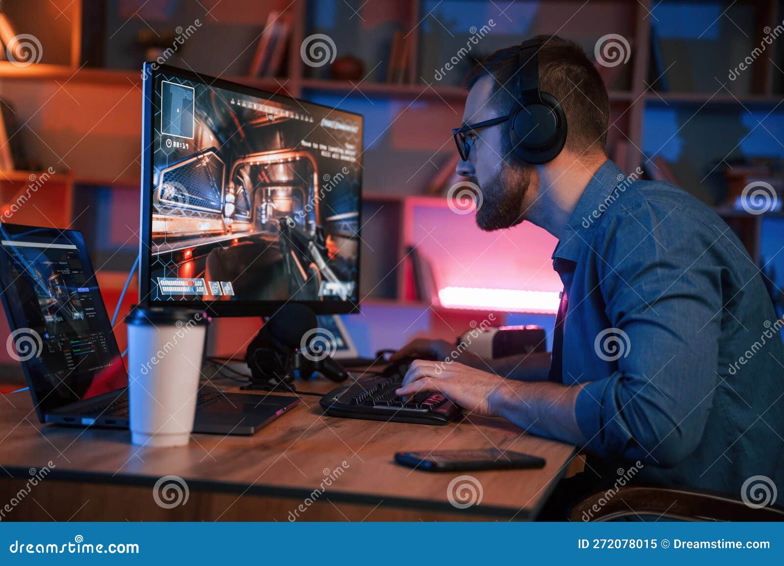 Concentrated Man is Playing the Shooter Game on His Computer. Neon ...