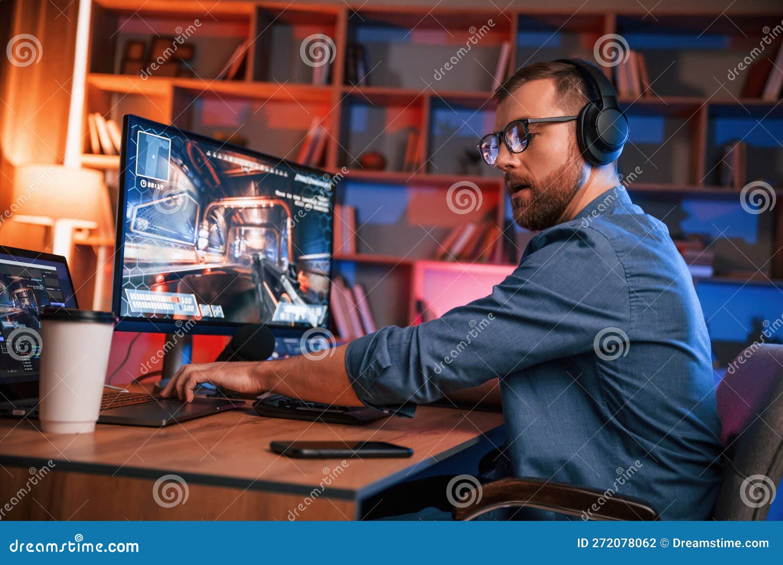 Concentrated Man is Playing the Shooter Game on His Computer. Neon ...