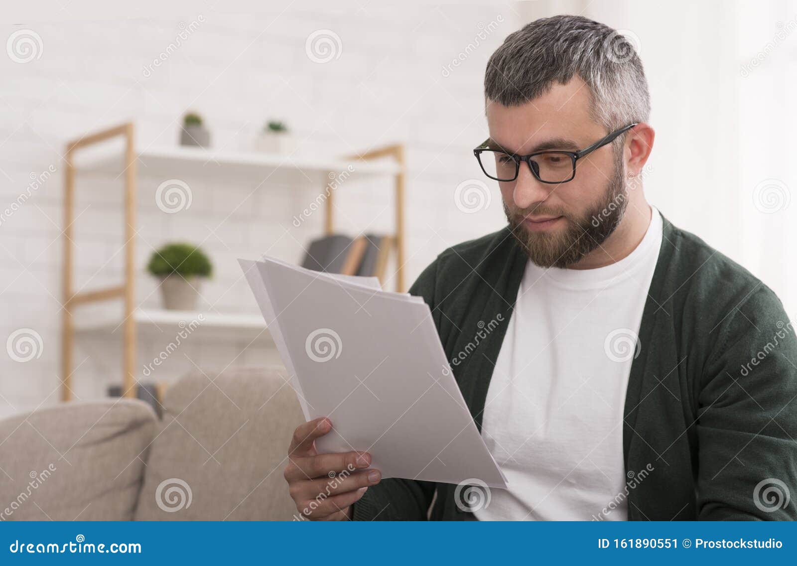 Concentrated Man Reading Printed Article Education At Home Stock Image