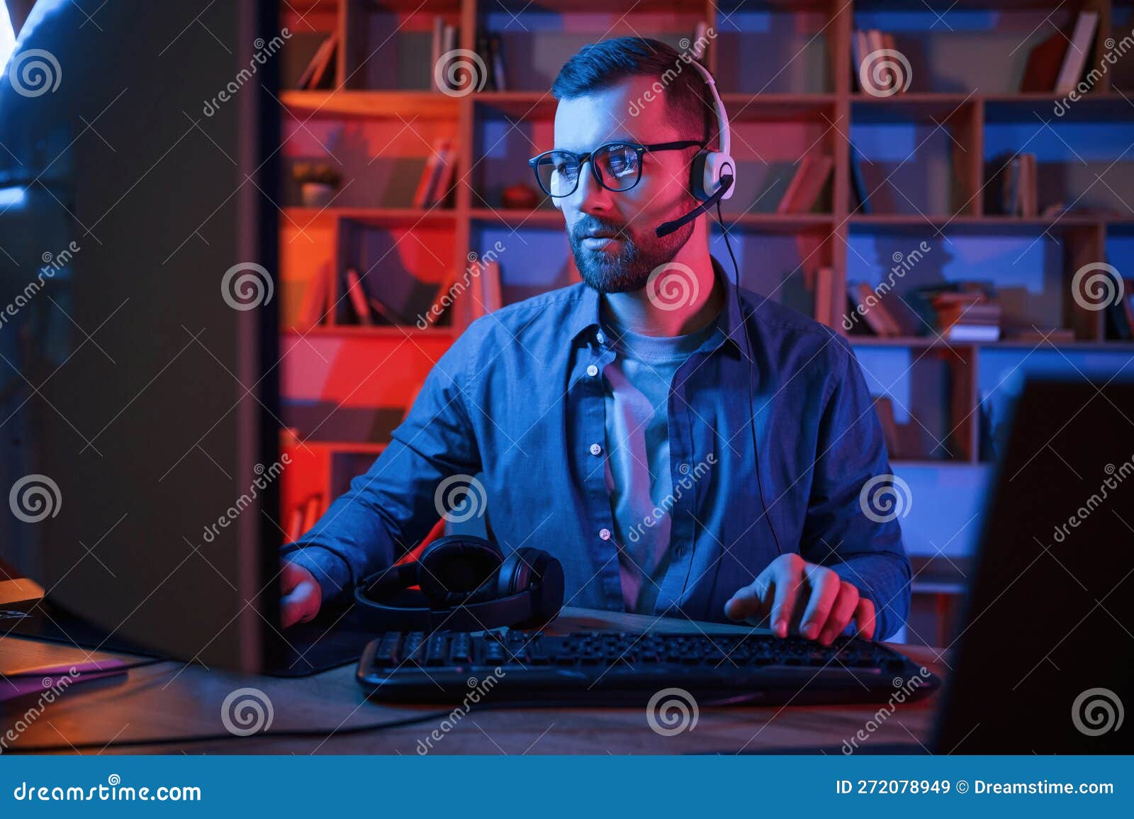 Concentrated Man is Sitting by a Computer Indoors at Home. Neon ...