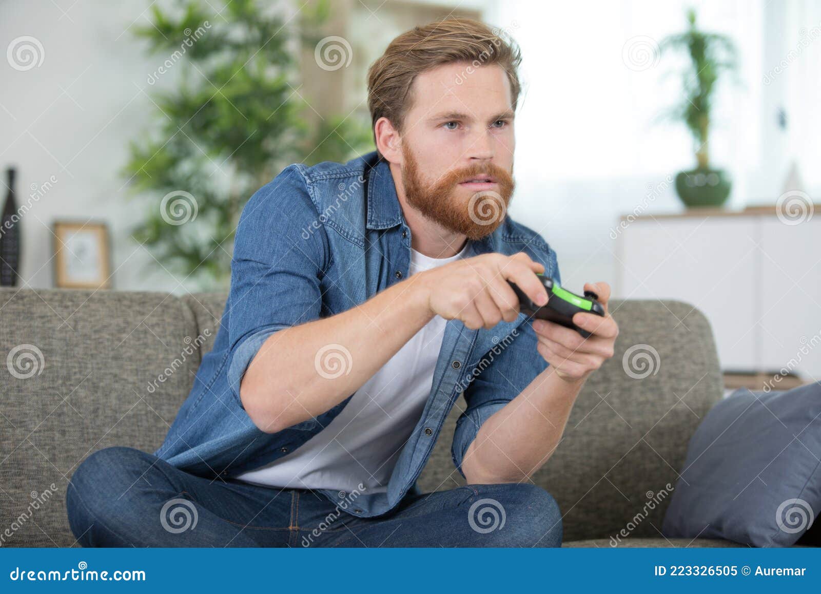 Concentrated Man Sitting on Sofa and Playing Computer Games Stock Image ...