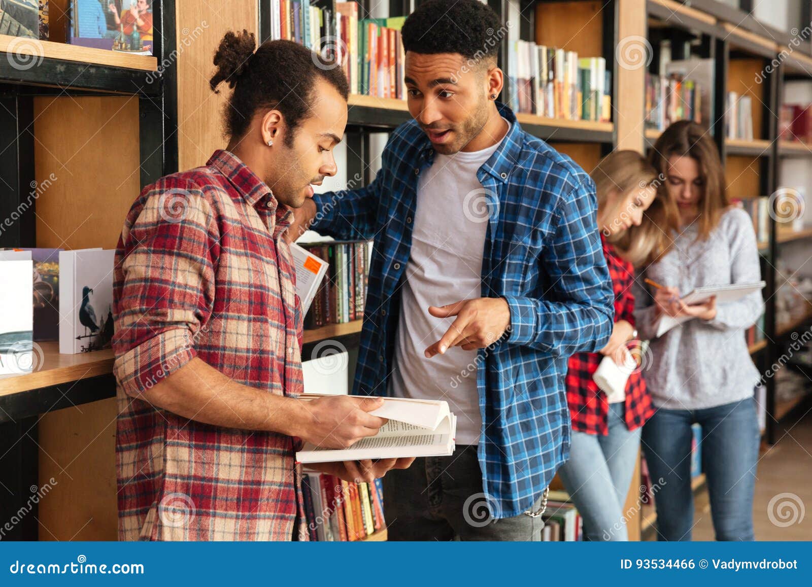 Concentrated Men Students Standing in Library Reading Book. Stock Photo ...