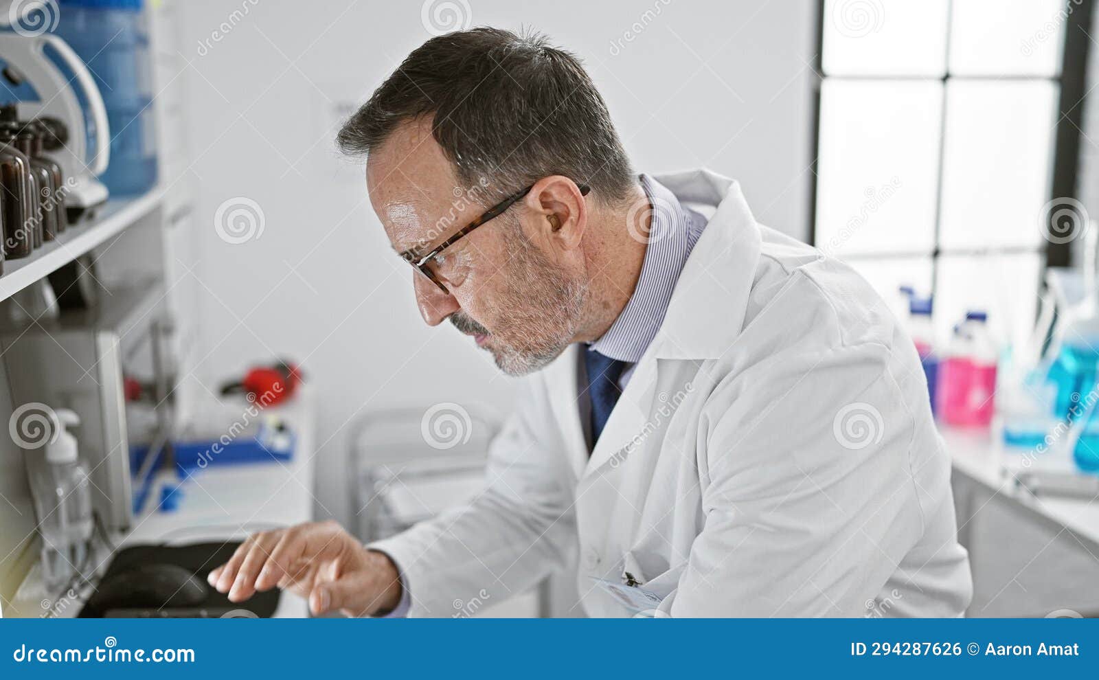Concentrated Middle-aged Man with Grey Hair, Immersed in Groundbreaking ...