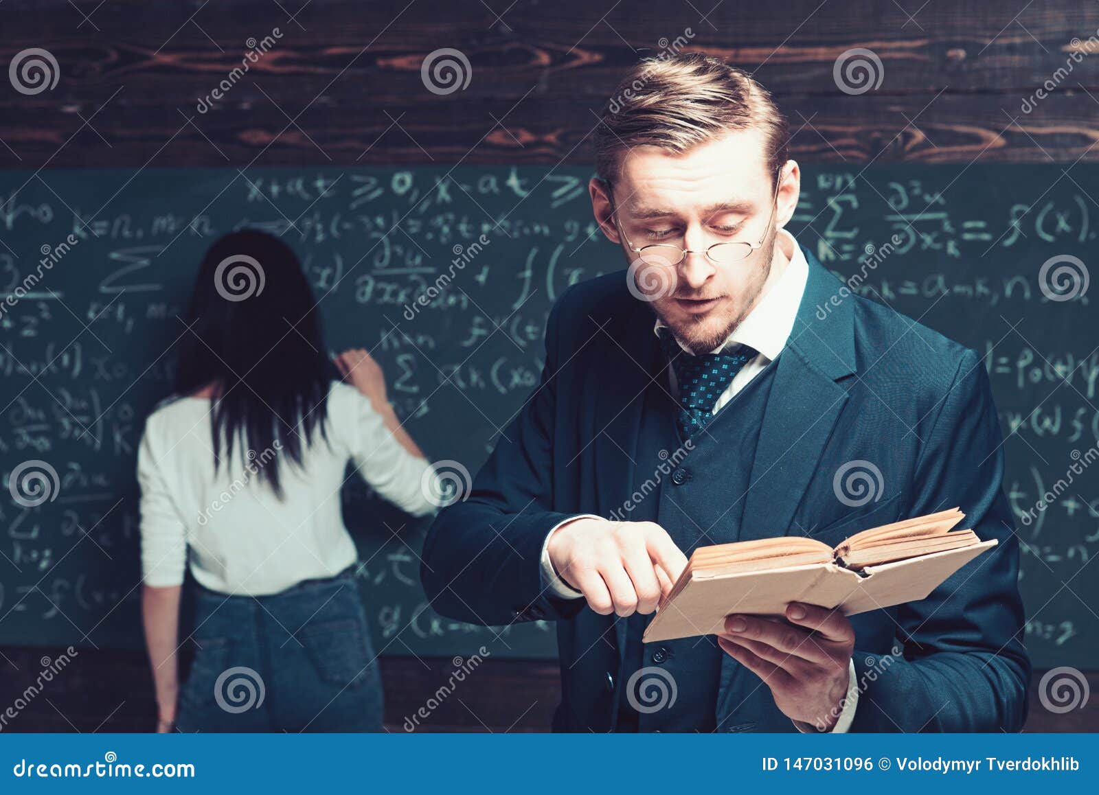 Concentrated Professor Reading Article To the Class while Young Female ...