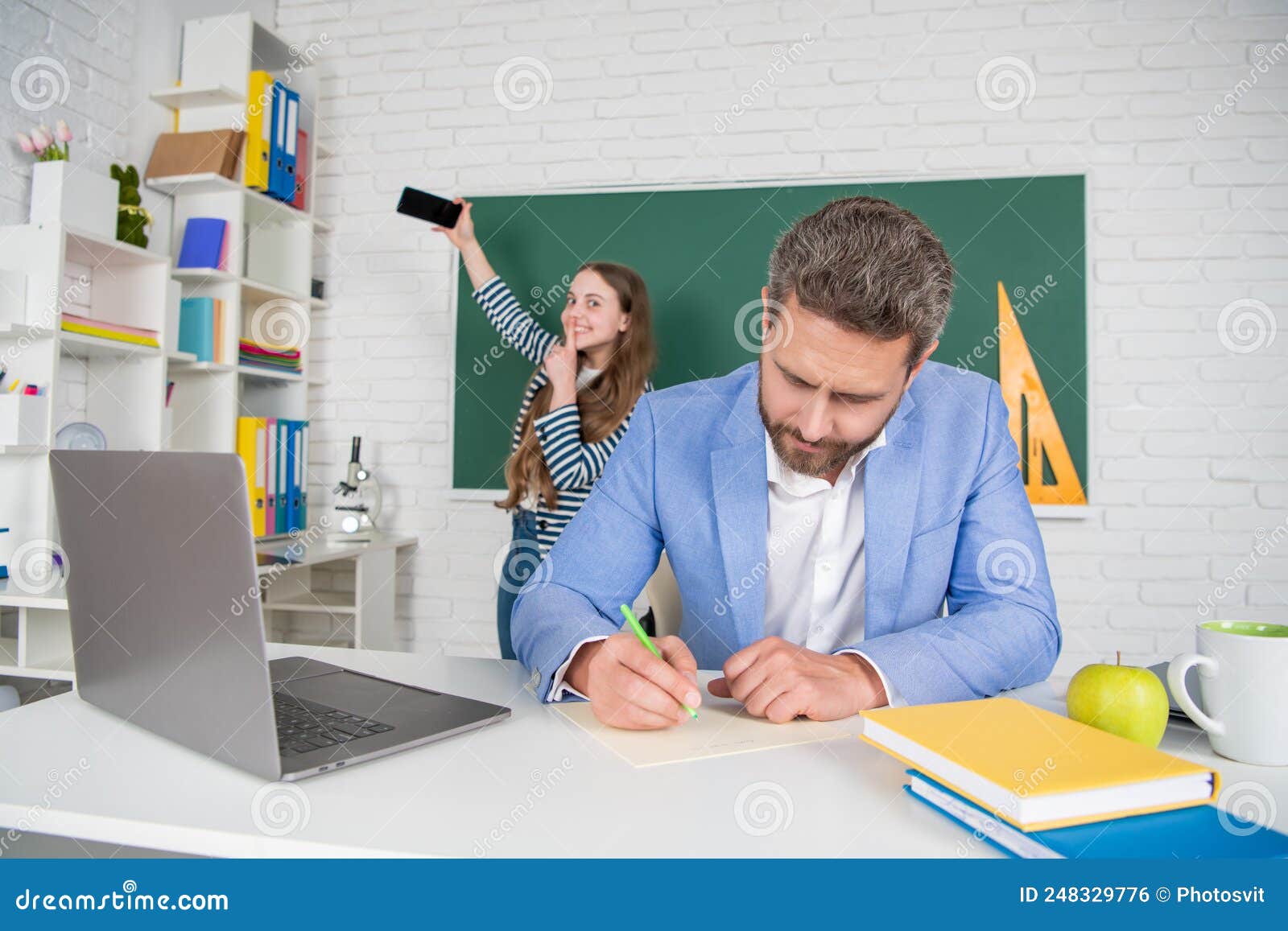 Concentrated School Teacher In Classroom With Selective Focus Of Kid At ...