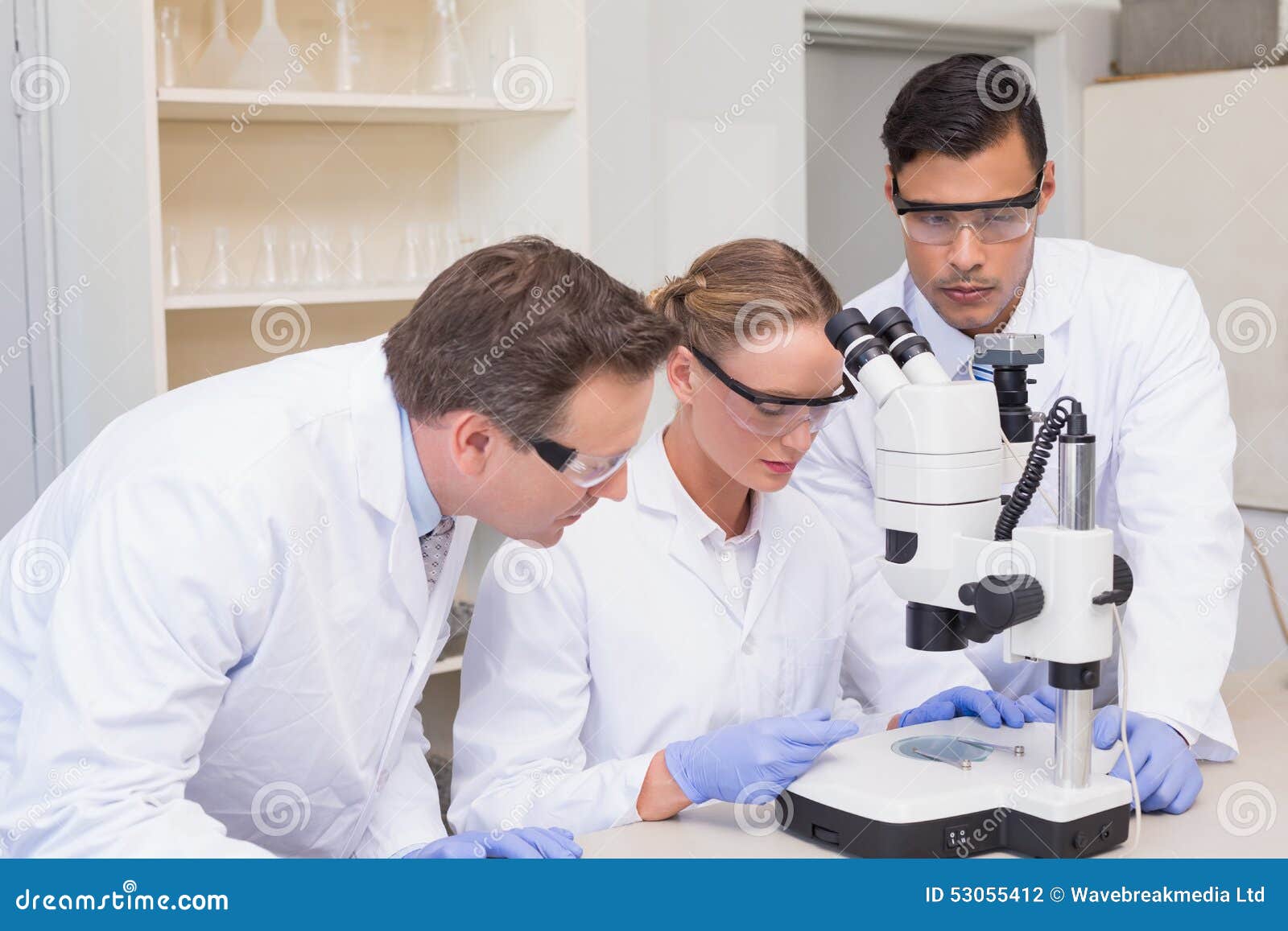 Concentrated Scientists Working Together with Microscope Stock Photo ...