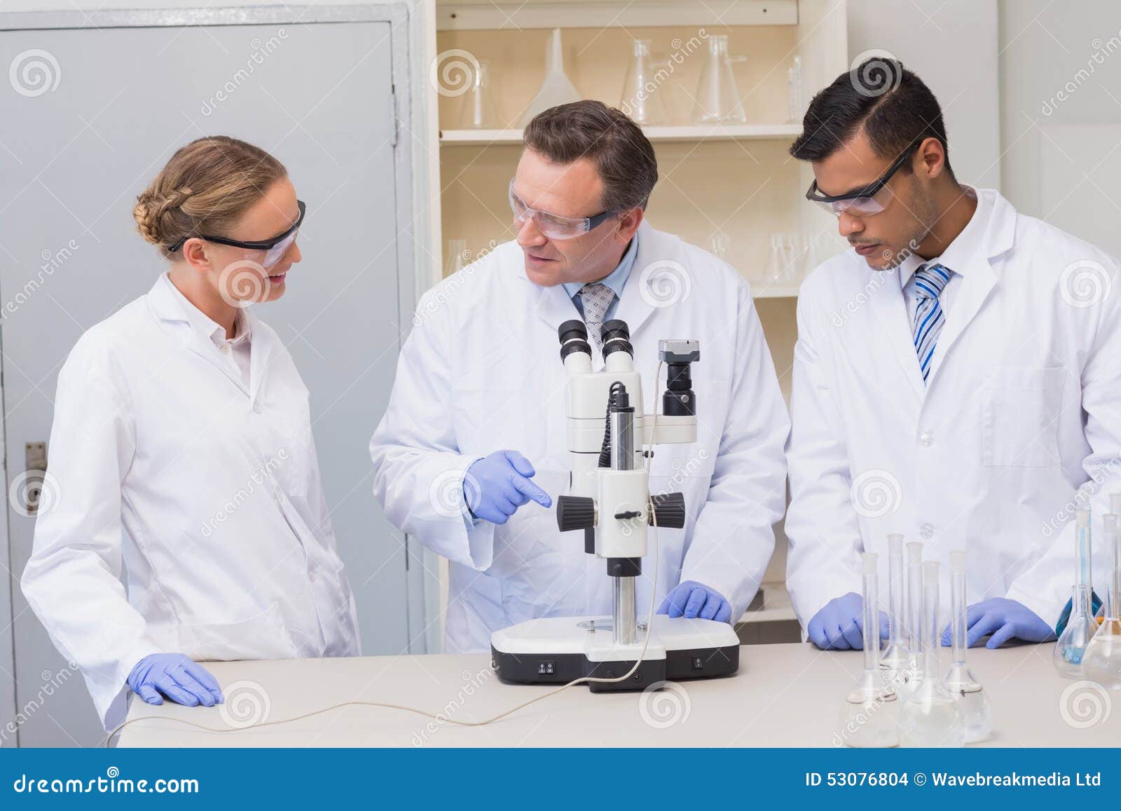 Concentrated Scientists Working Together with Microscope Stock Photo ...