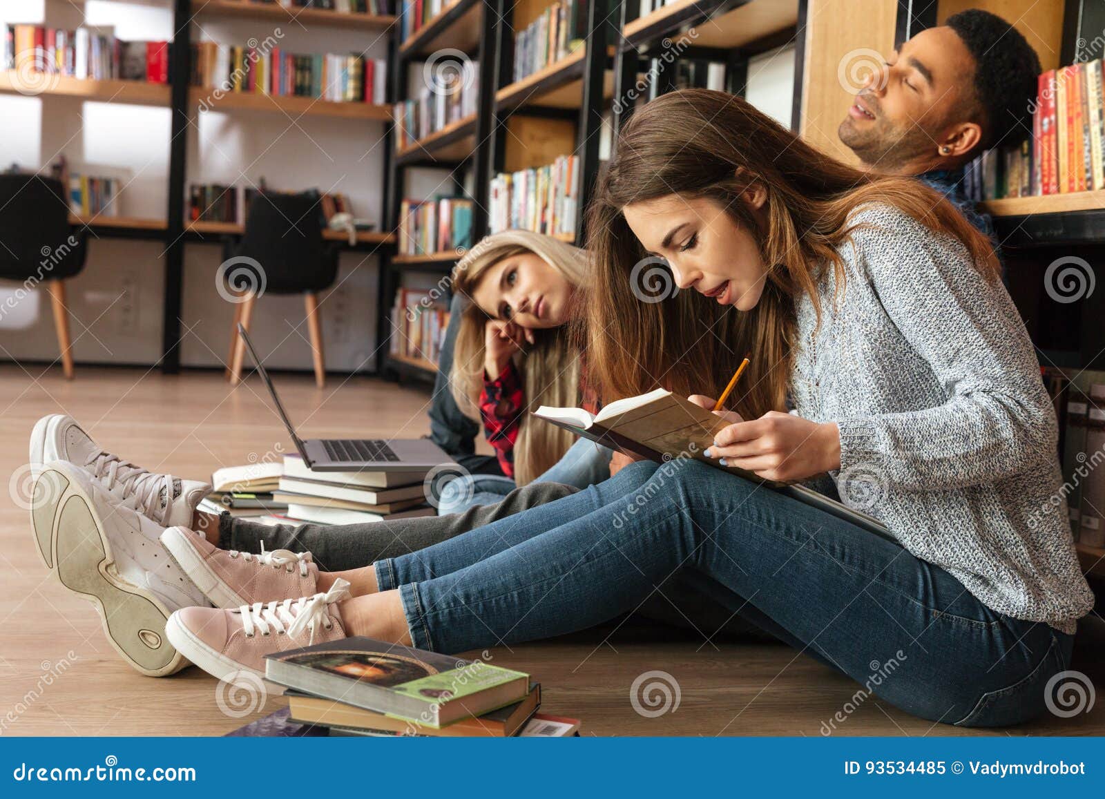 Concentrated Students Sitting in Library on Floor Reading Books. Stock ...