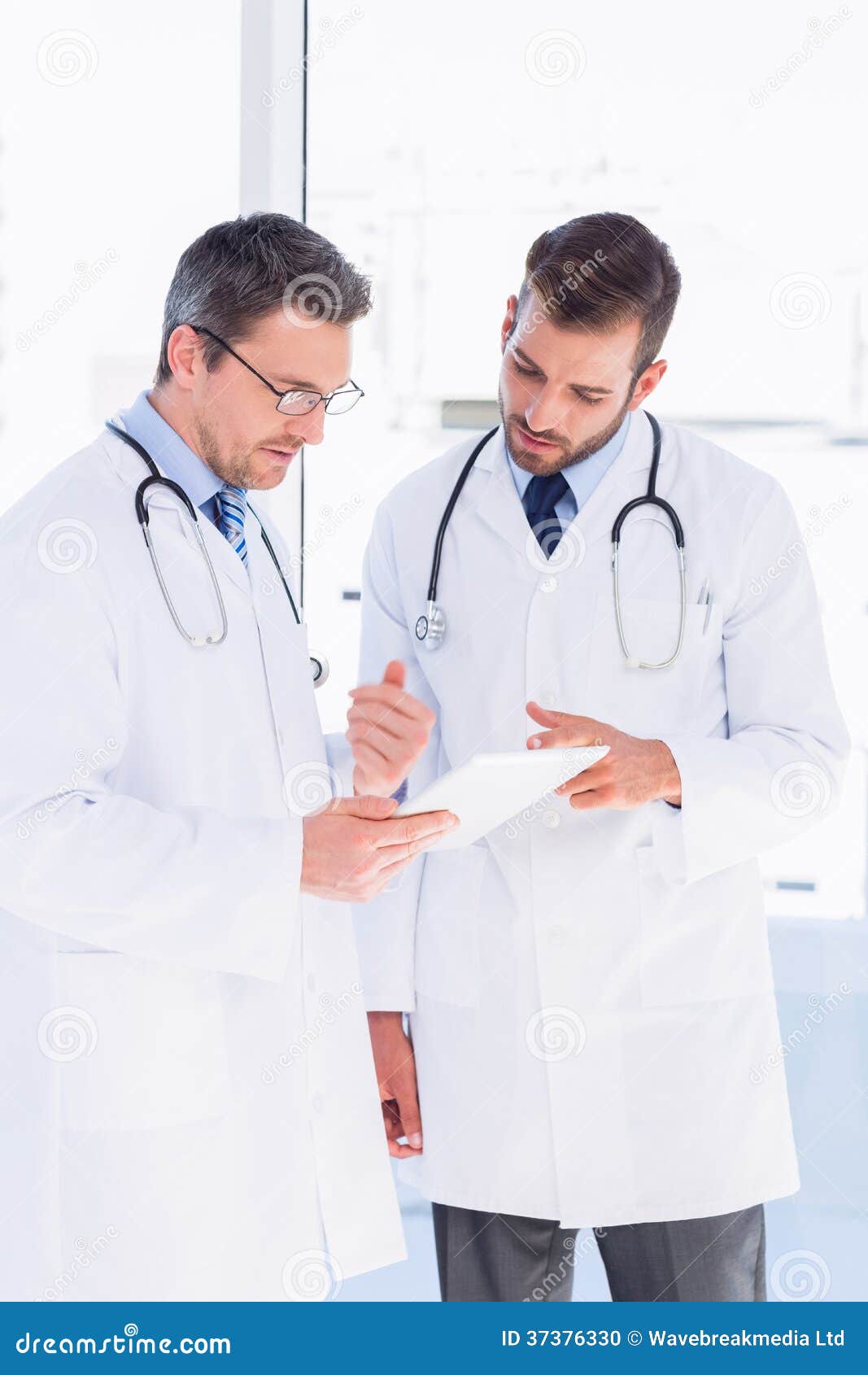 Concentrated Two Male Doctors Using Digital Tablet Stock Photo - Image ...